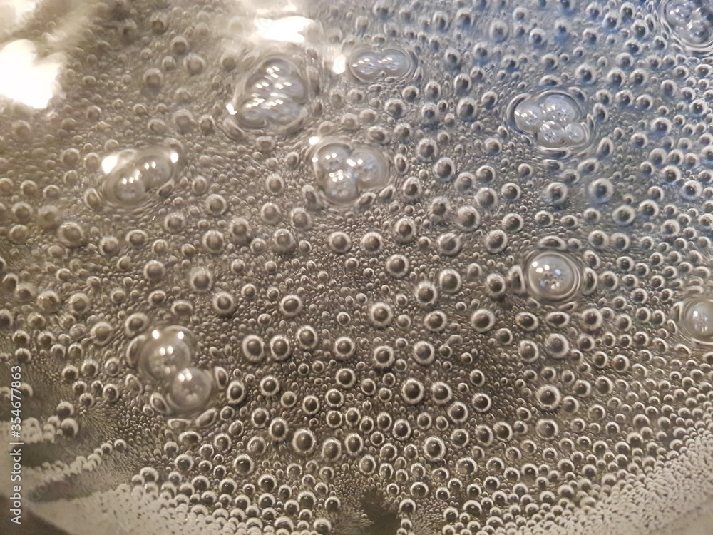 bubbles in boiling water on stove background Stock Photo | Adobe Stock