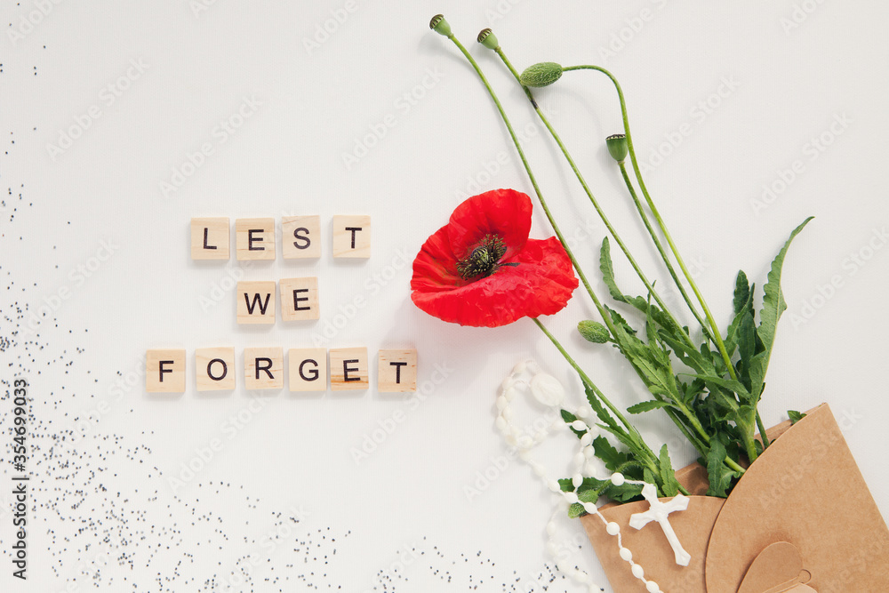 Red poppy flowers in envelope on white background. Wooden alphabet text ...