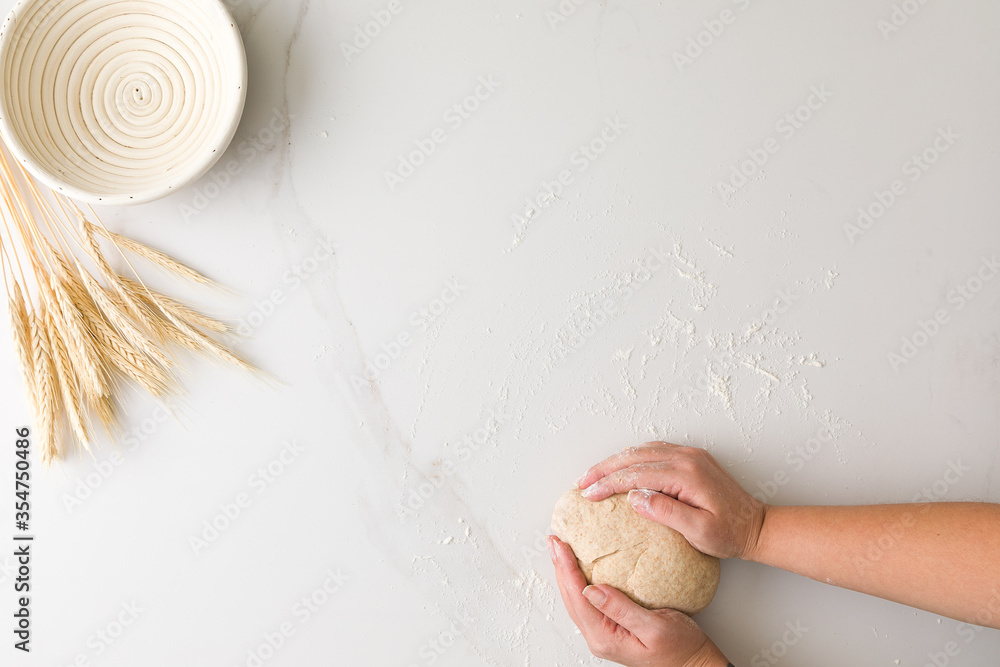 Top view of female hand molding bread dough in a marble table with an ...