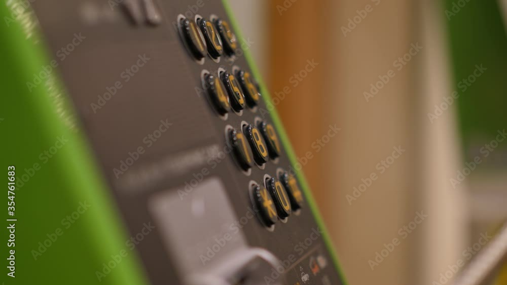 Woman press buttons on modern digital payphone, close up shot with ...