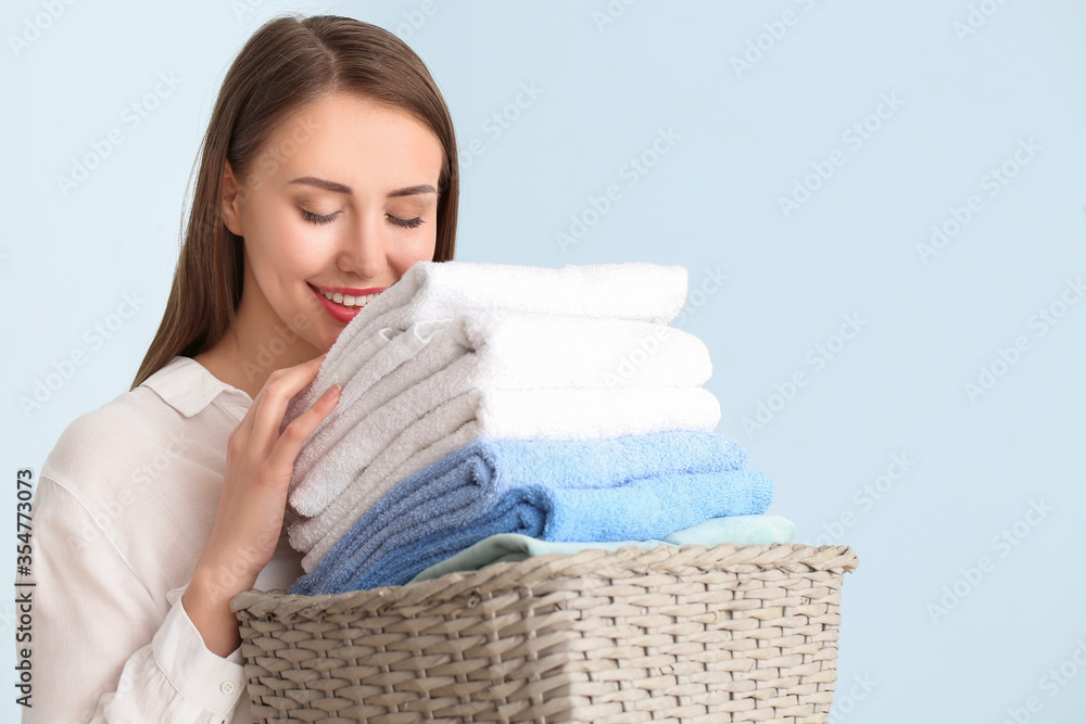 Young woman with clean laundry on light background Stock Photo | Adobe ...
