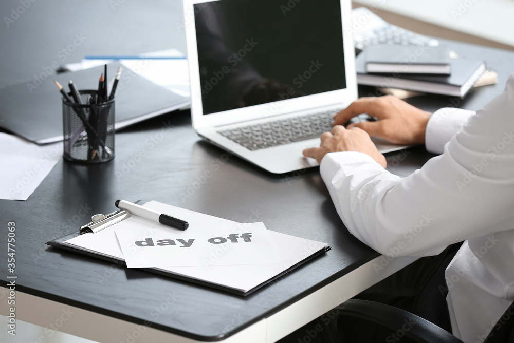 Paper with text DAY OFF on table of young businessman in office Stock ...