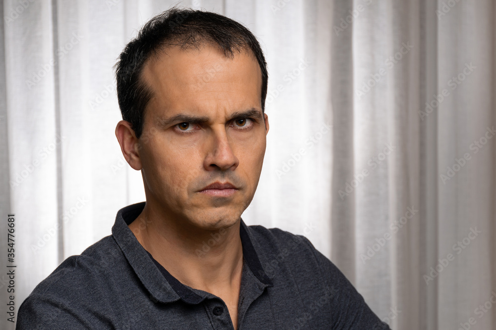 44 year old mature man in a polo shirt and an angry look staring at the ...