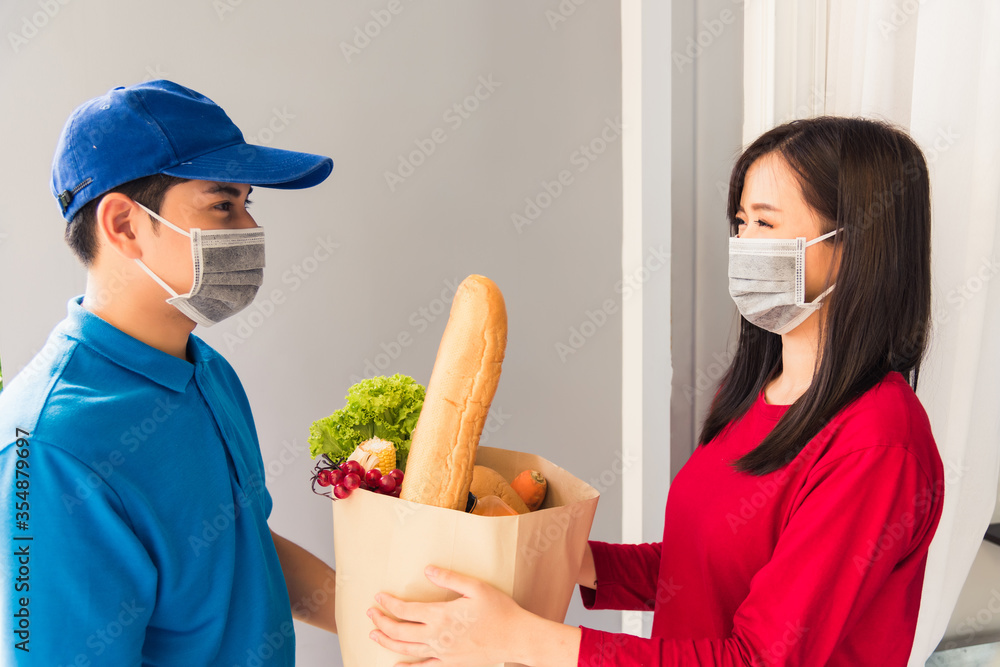 Asian young delivery man in uniform wear protective face mask he making ...