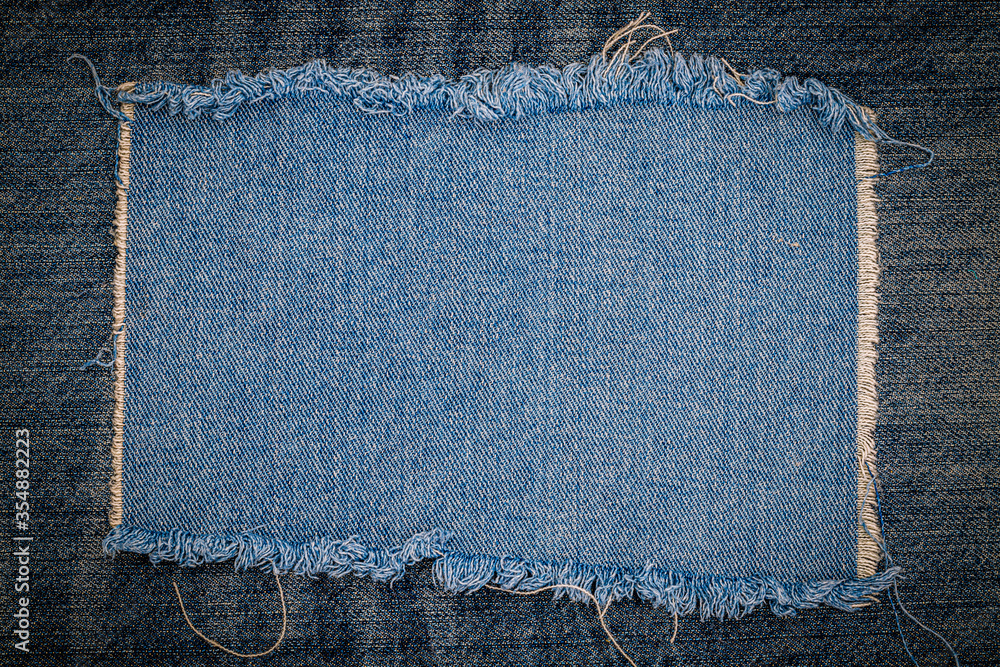 Destroyed torn denim blue jeans fabric frame on blue jeans background ...