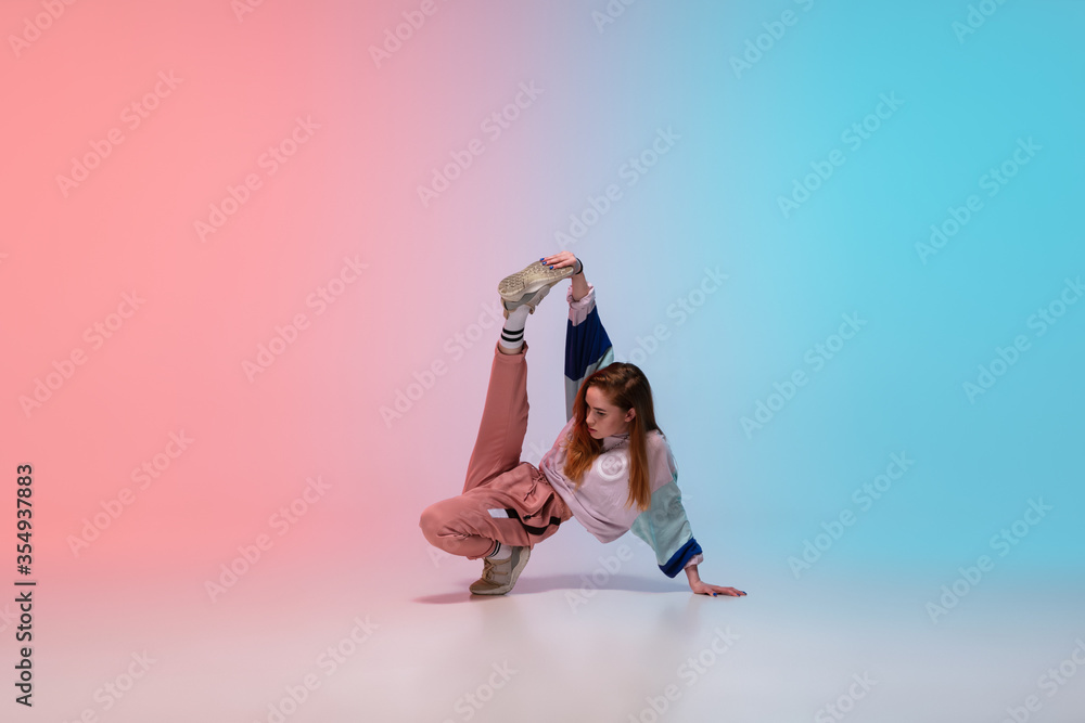 Beautiful sportive girl dancing hip-hop in stylish clothes on colorful ...