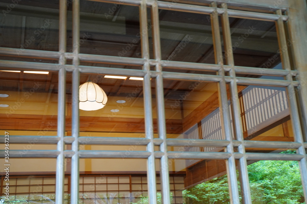 Japanese old wood architecture with big glass window and green garden ...