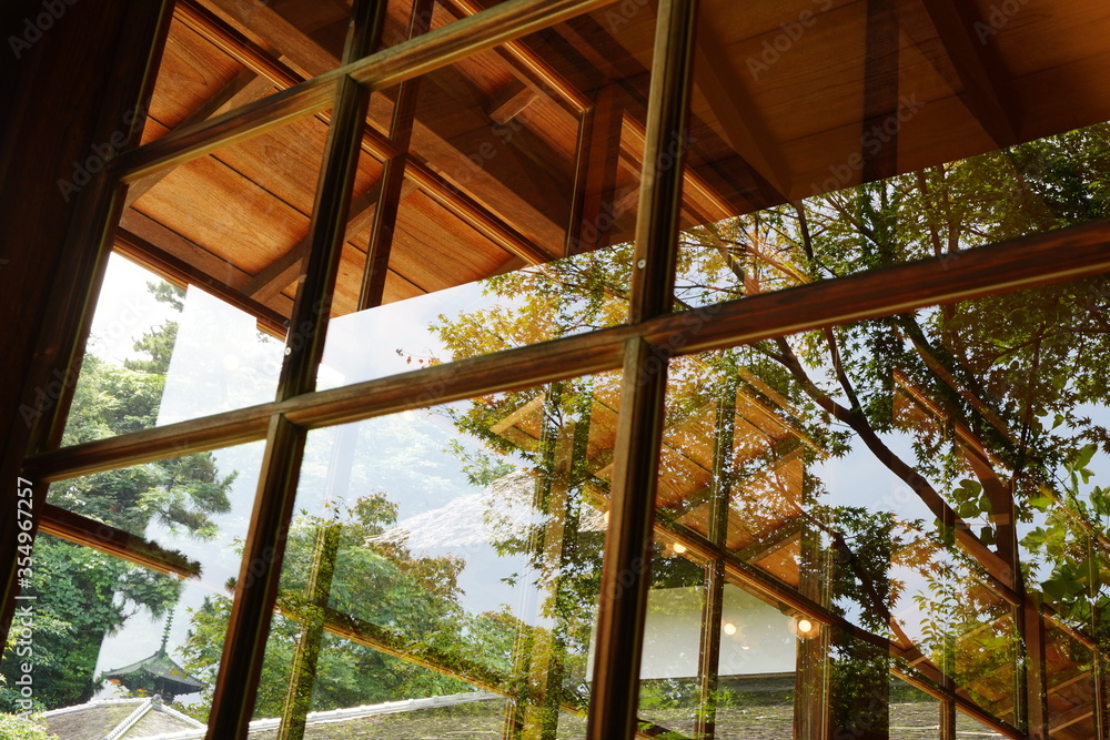 Japanese old wood architecture with big glass window and green garden ...