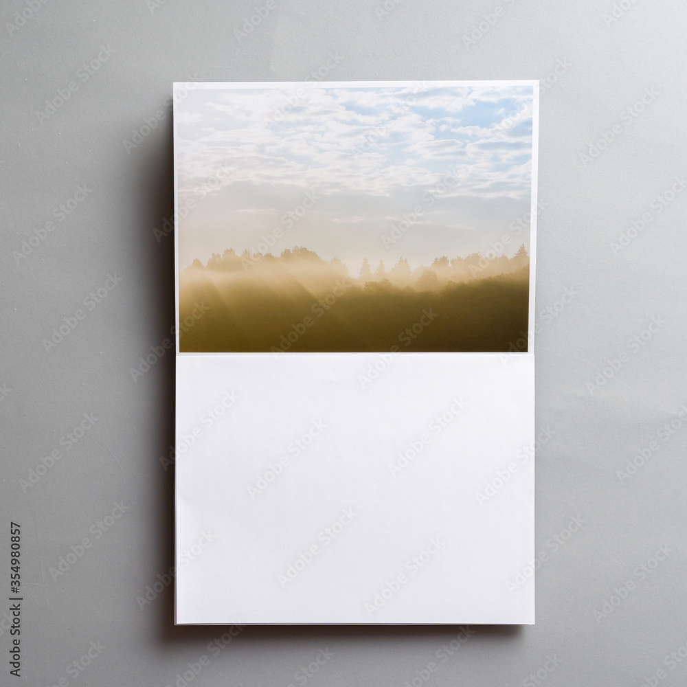 Photo-book in expanded form, on a gray background, with one empty photo ...