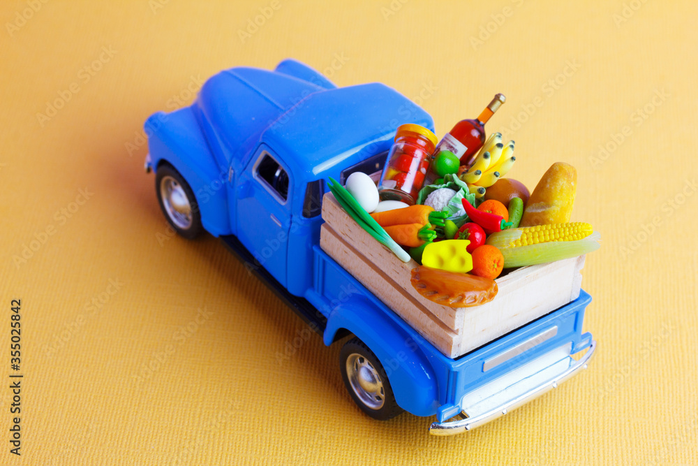 Blue toy car carries food and drinks in a wooden box. Food delivery ...