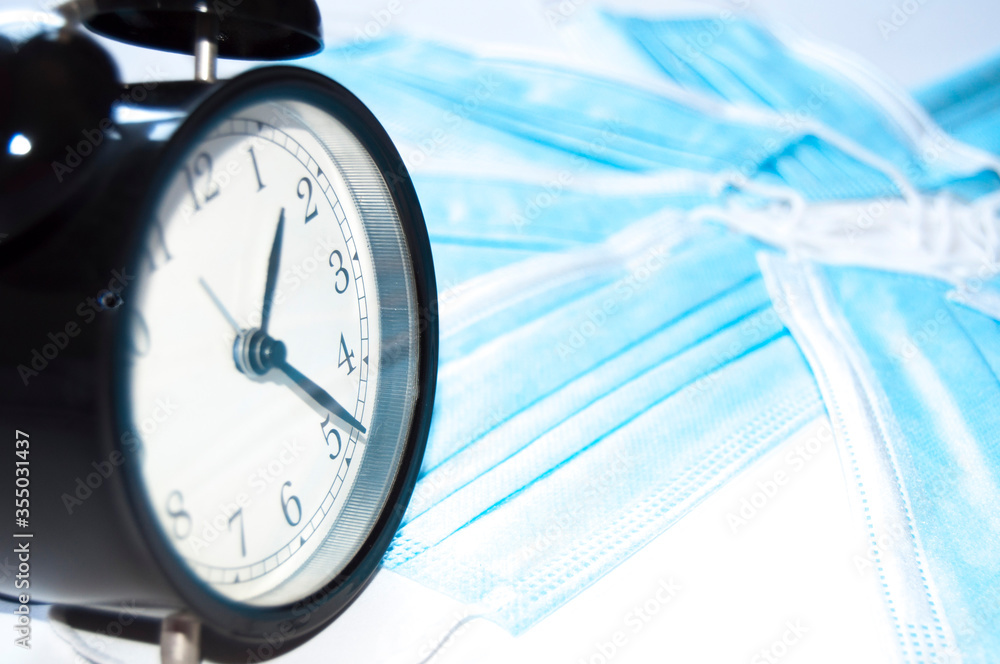 Surgical face masks and clock indicating the time Stock Photo | Adobe Stock