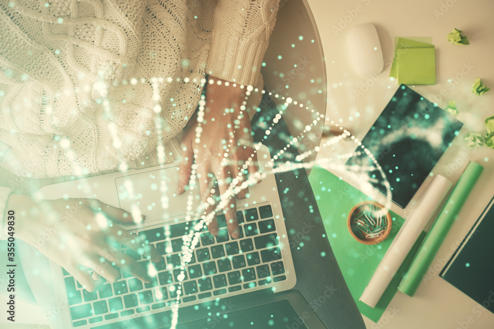 Double exposure of woman hands working on computer and DNA hologram ...