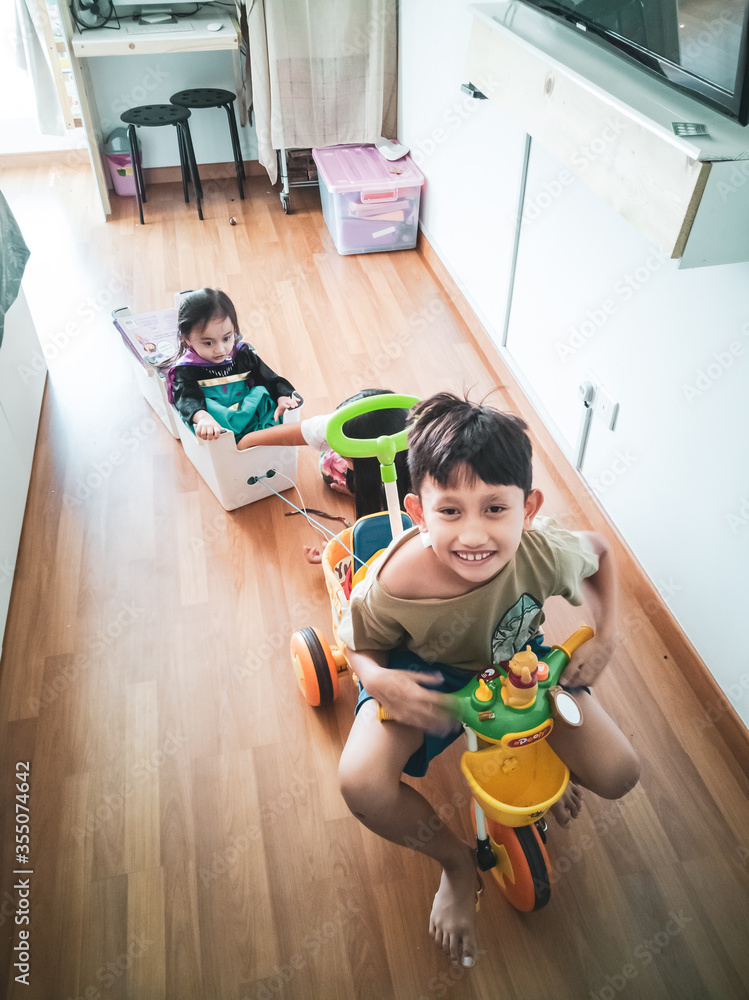 Kuala Lumpur, Malaysia - Mar 17, 2020: Children playing bicycle at home ...