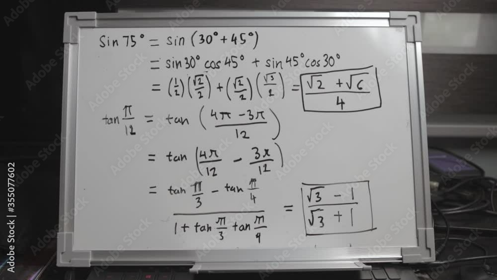 Hand writing solution to a mathematical equation on whiteboard ...