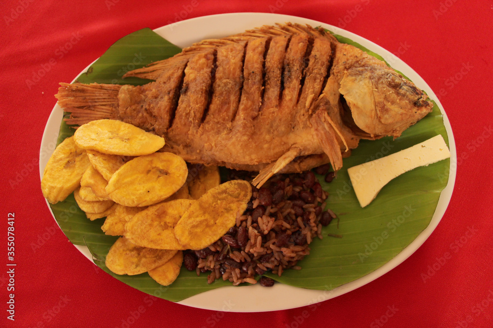 Fried Central American fish with plantain chips, rice and beans ...
