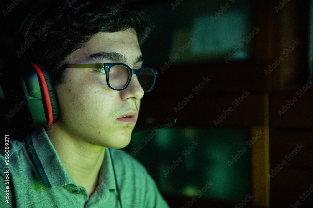 Game action during a video gaming session. The Caucasian boy with wavy ...