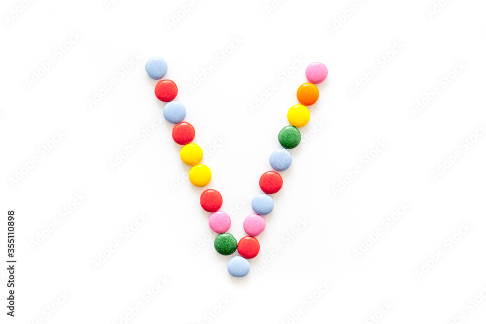 Candies font alphabet. Letter V isolated top view Stock Photo | Adobe Stock