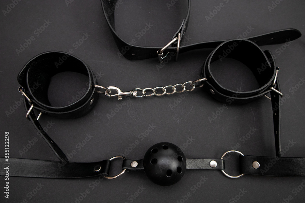 Leather whip, handcuffs and gag on black background. Top view Stock ...
