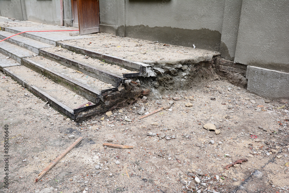 Ruined, badly broken, damaged front concrete stairs, porch steps ...