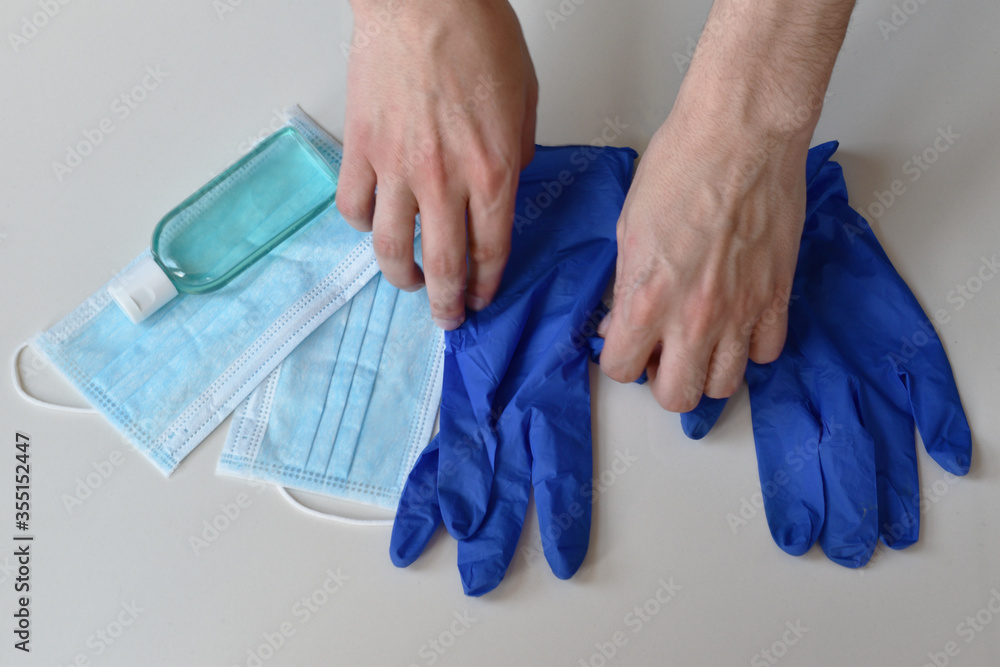 Man putting on latex gloves, man's hands taking rubber gloves, medical ...