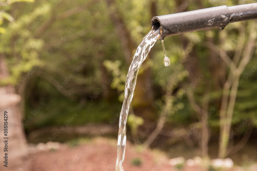 Pure spring water. Waterfall from the rock, cold and clear drinking ...