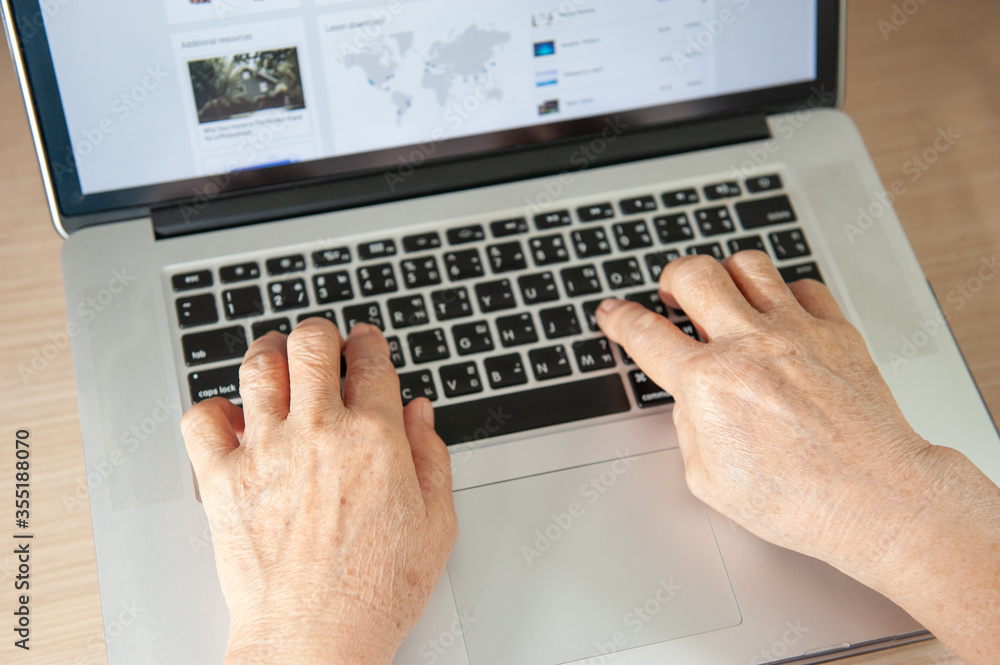 Elderly woman hands typing the keyboard on the notebook To enter the ...