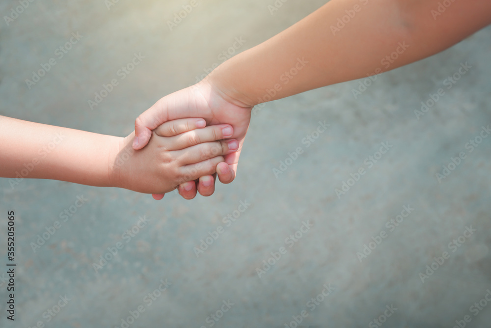 The child's right hand helps to pull one hand of the young child to ...