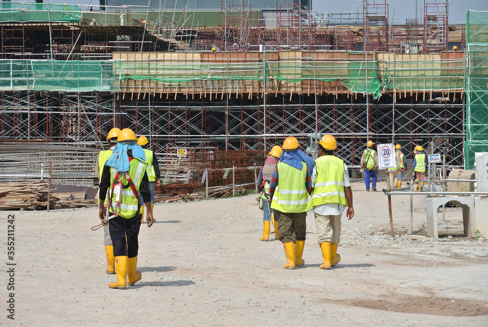 Foto de JOHOR, MALAYSIA -JUNE 17, 2016: Construction workers walking in the construction site ...