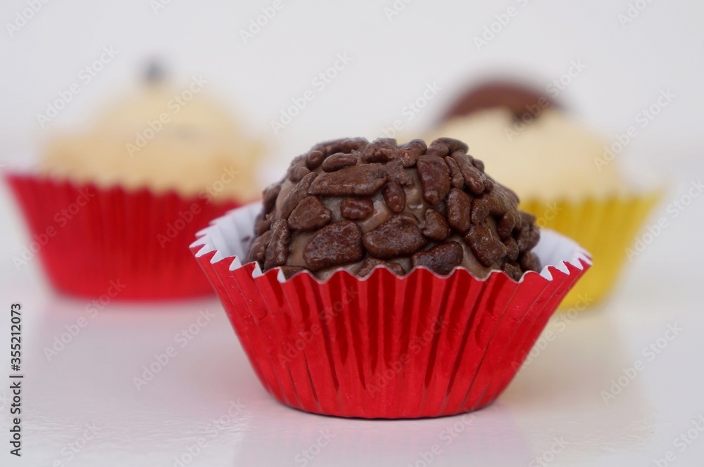 Close up de Brigadeiro com Beijinhos ao fundo. Doces brasileiros. Festa ...