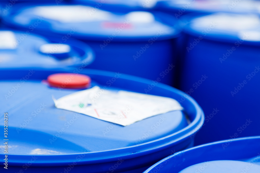 blue plastic barrels with poison in close-up with blur in background ...