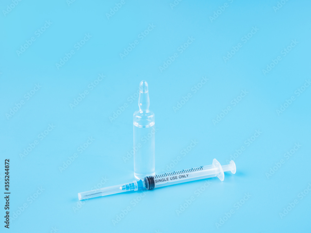 Medical syringe lies next to ampoule with a drug. Light background ...