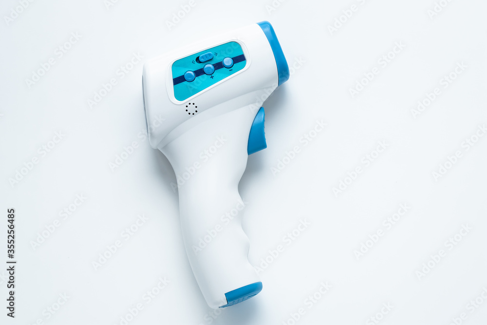 Infrared electronic thermometer gun on a white background. Copy space ...