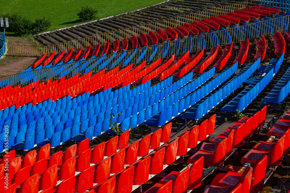 The stands of the old football stadium with rows of plastic seats in ...