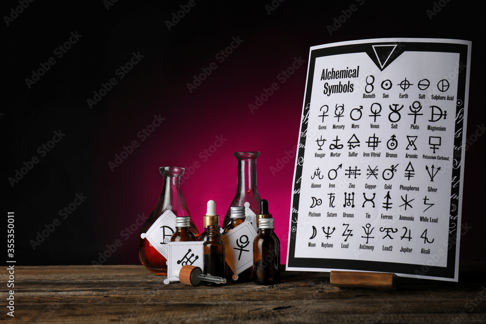 Potions with alchemical symbols on table Stock Photo | Adobe Stock