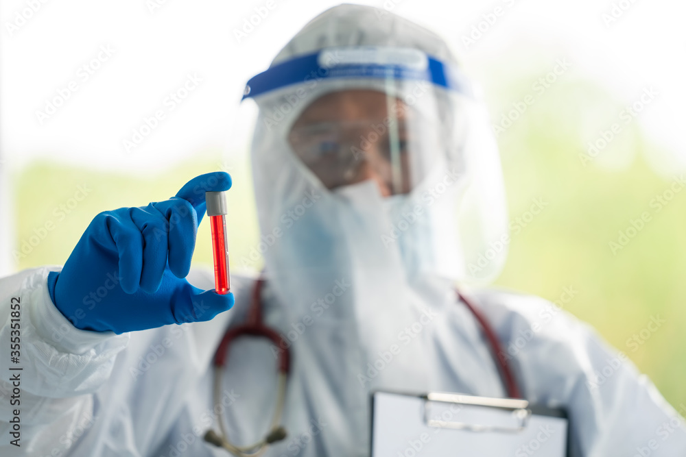 Scientist wear hazmat PPE protective clothing in lab coat,looking at ...