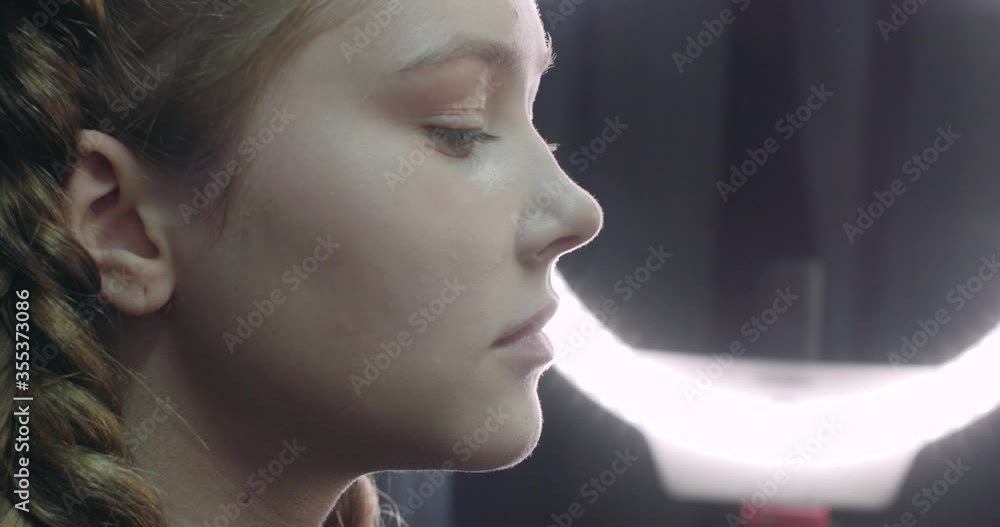 Portrait of a pretty girl, makeup artist applies makeup and toning of ...