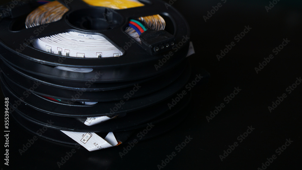 Coils of rgb led strip on a black table. Led strip for creative ...