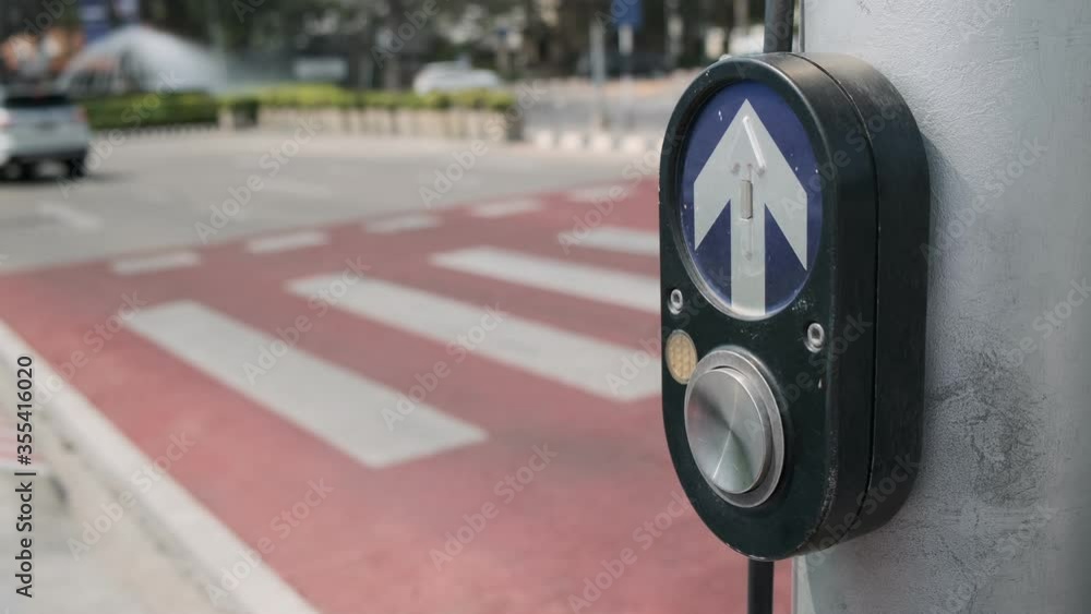 woman pedestrian presses finger on traffic signal switch button at ...