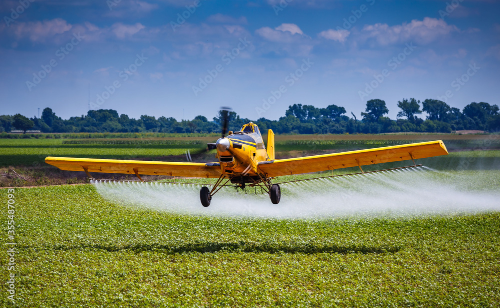 Foto de Yellow Crop Duster Airplane Aerially Applies Pesticide to ...