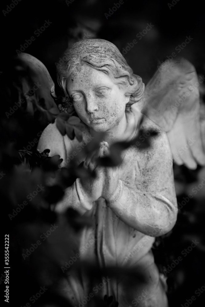 Foto de Sad angel. Ancient stone statue with a sweet expression as ...