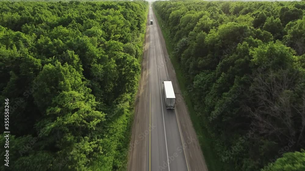 One Semi Truck with white trailer and cab driving / traveling alone on ...