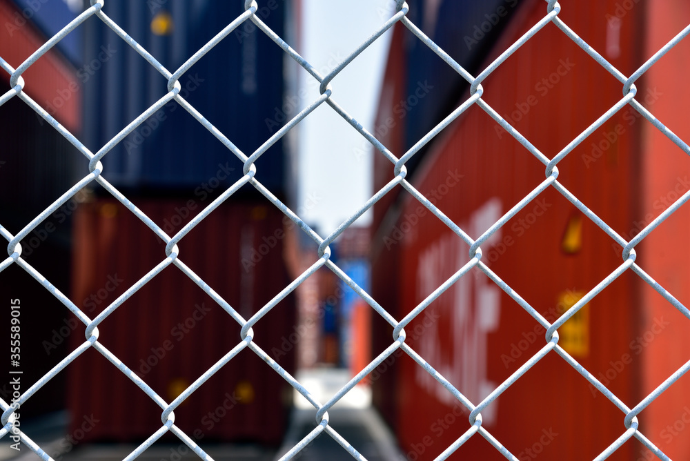 Wire mesh fence enclosing the maritime transport terminal: shipping ...