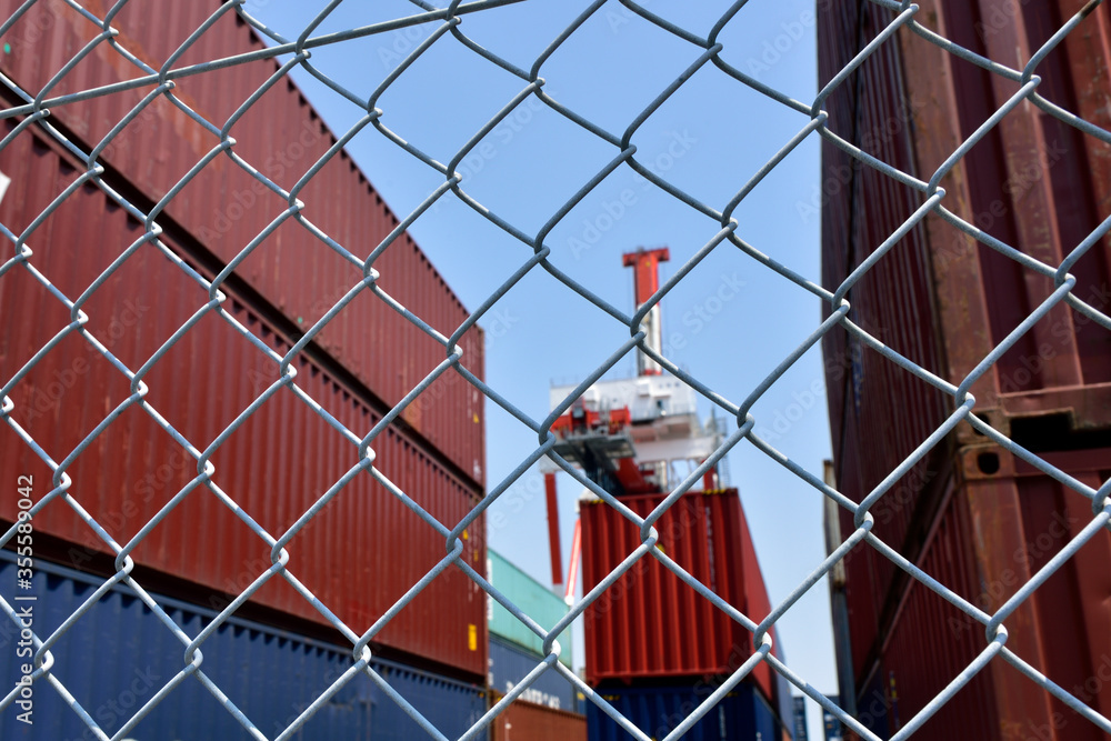 Wire mesh fence enclosing the maritime transport terminal: shipping ...