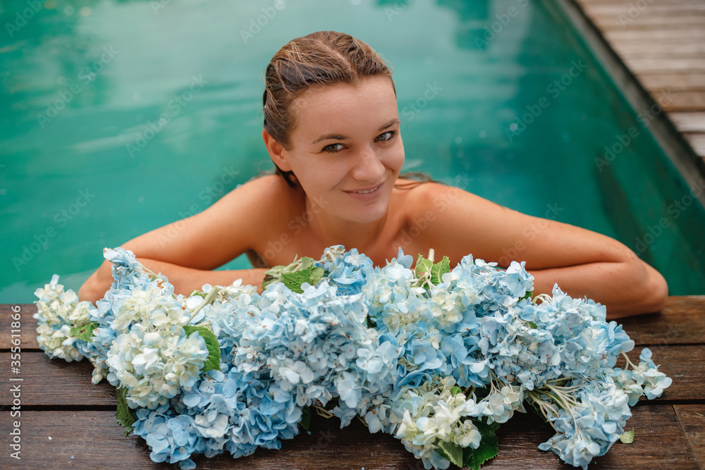 Beautiful young woman at swimming pool look at the camera. Beautiful ...