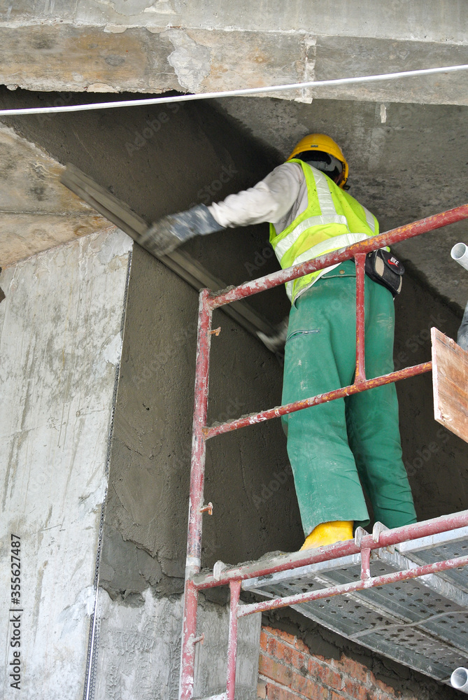 SEPANG, MALAYSIA -SEPTEMBER 20, 2016: Construction workers plastering ...