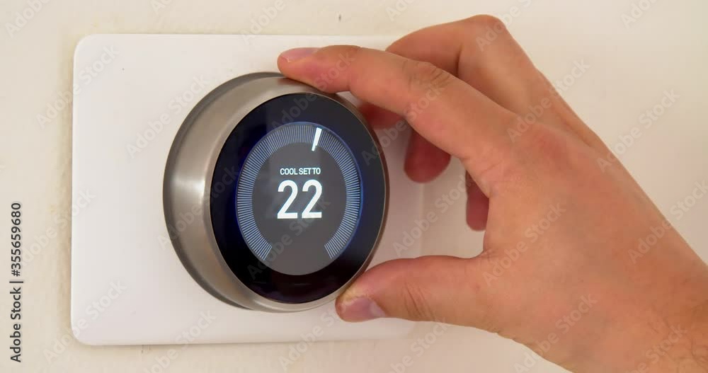 A persons hand cooling down the room temperature on centigrade celsius ...