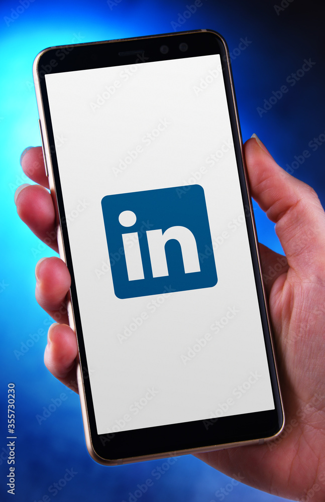 Hand holding smartphone displaying logo of LinkedIn Stock Photo | Adobe ...