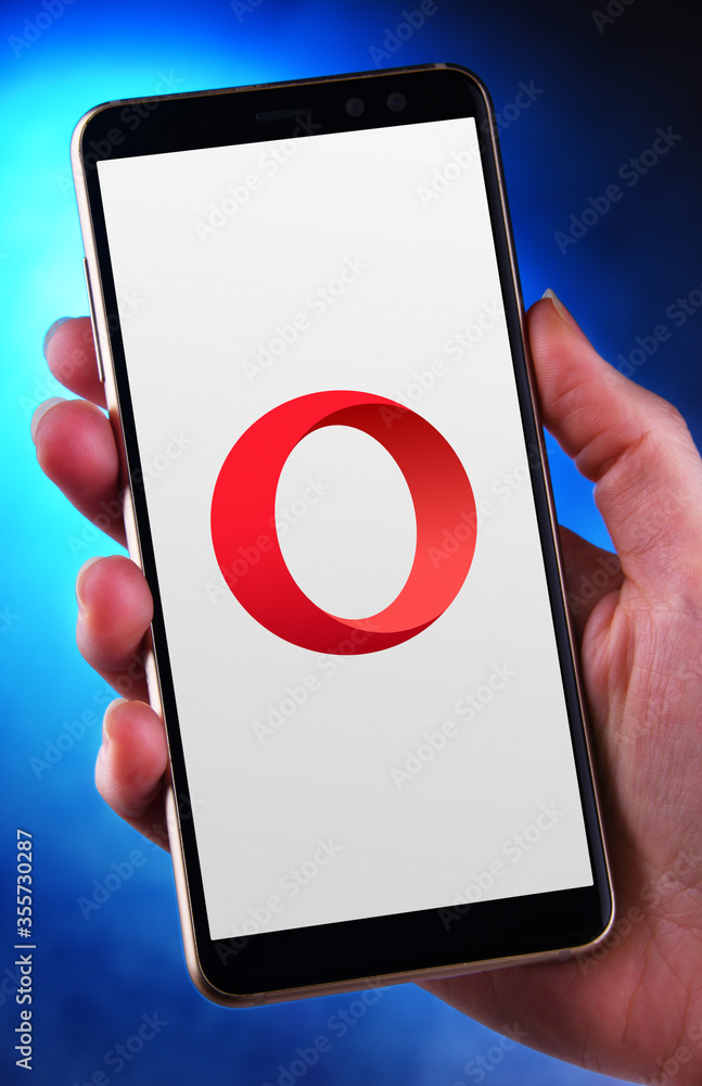 Hand holding smartphone displaying logo of Opera Stock Photo | Adobe Stock