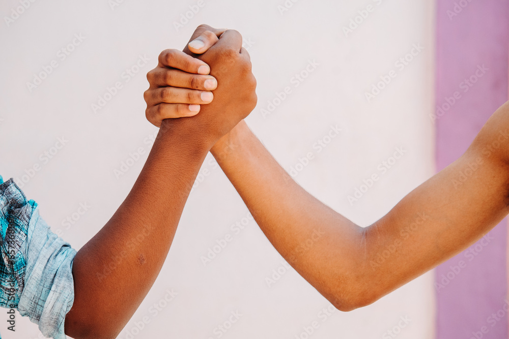 Black and white human hands in a modern handshake to show each other ...
