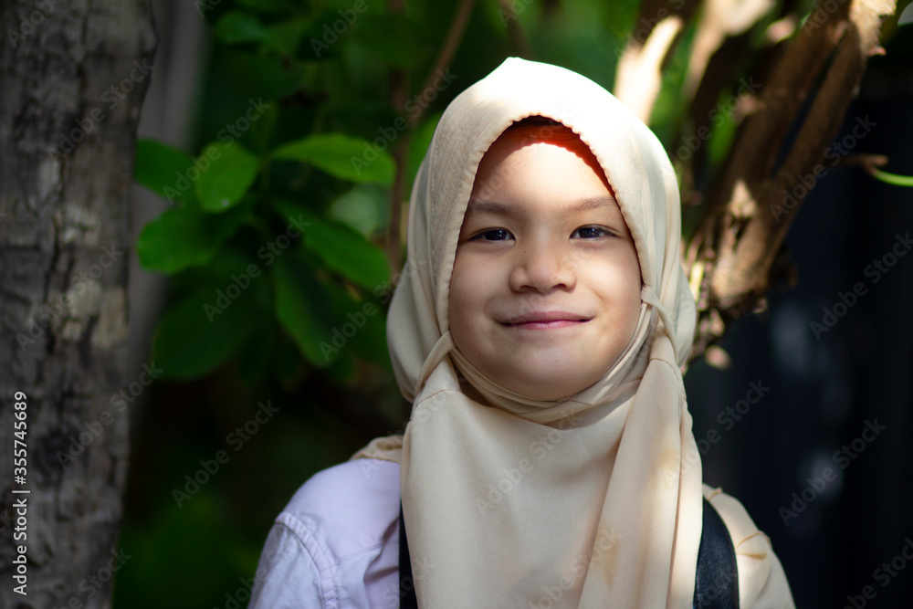 Muslim School kid.Pretty little girl in hijab looking and smile to ...